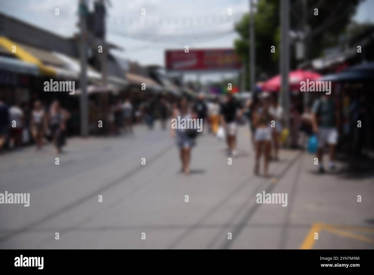 Busy outdoor market with people walking and shopping, blurred view ...
