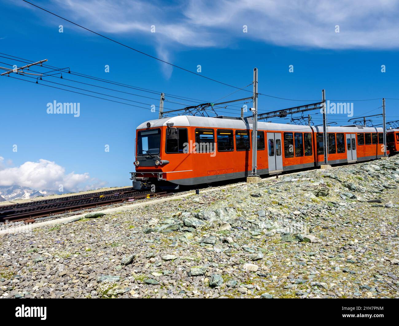 Red tourist train on Gornergrat railway near Matterhorn peak on blue ...