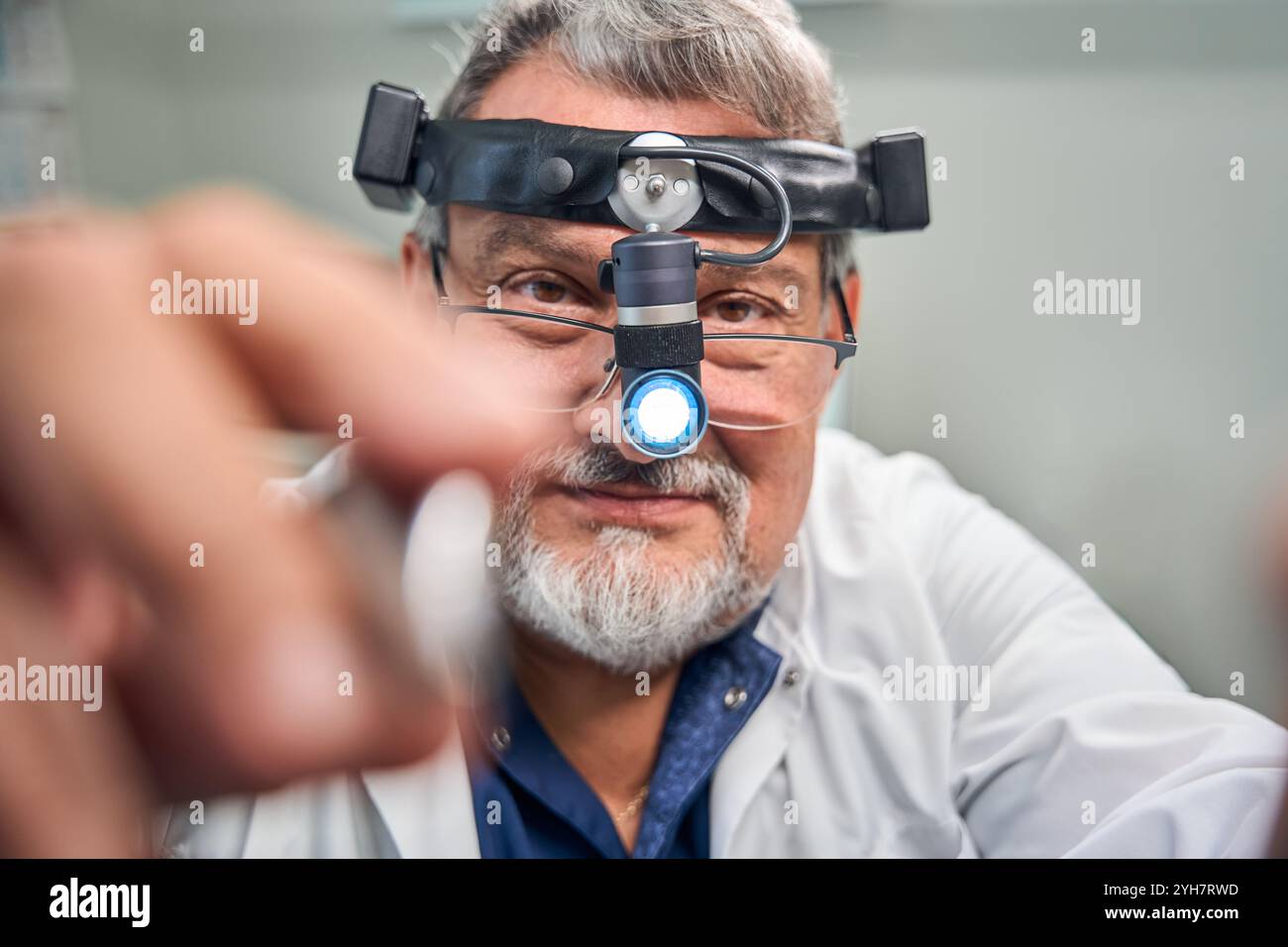 Doctor adjusting medical headlamp for eye examination Stock Photo - Alamy