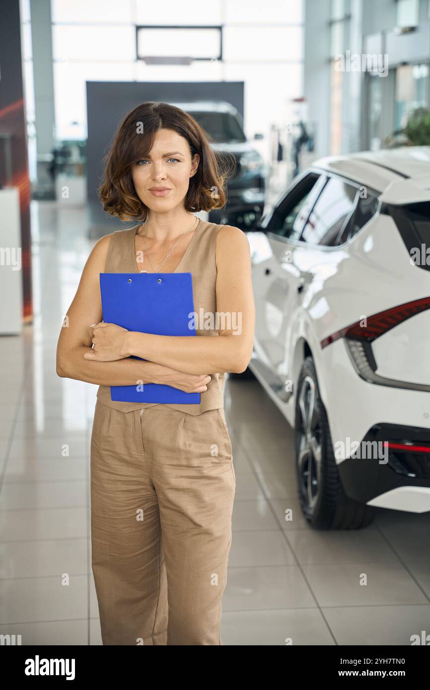 Female sales person at a car showroom Stock Photo - Alamy