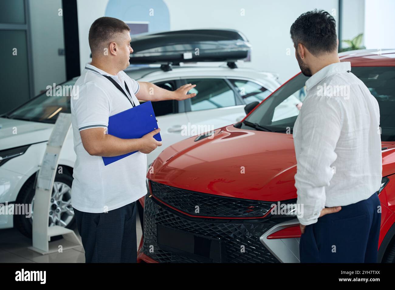 Salesman manager with file folder and male customer standing in car ...