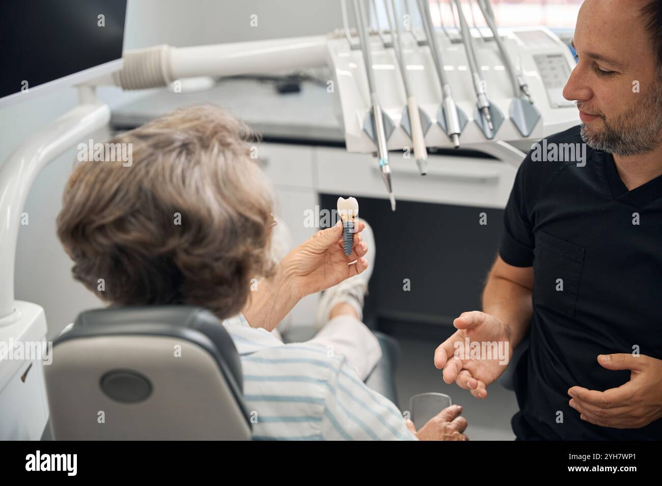 Elderly lady holds model of dental implant in her hands Stock Photo - Alamy