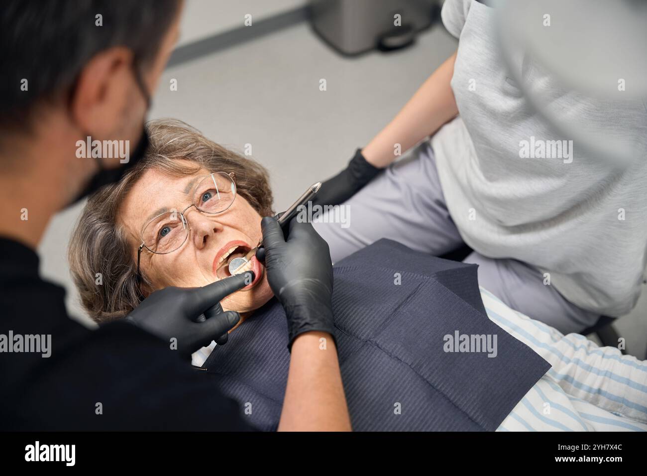 Dentist surgeon examines teeth of elderly lady Stock Photo - Alamy