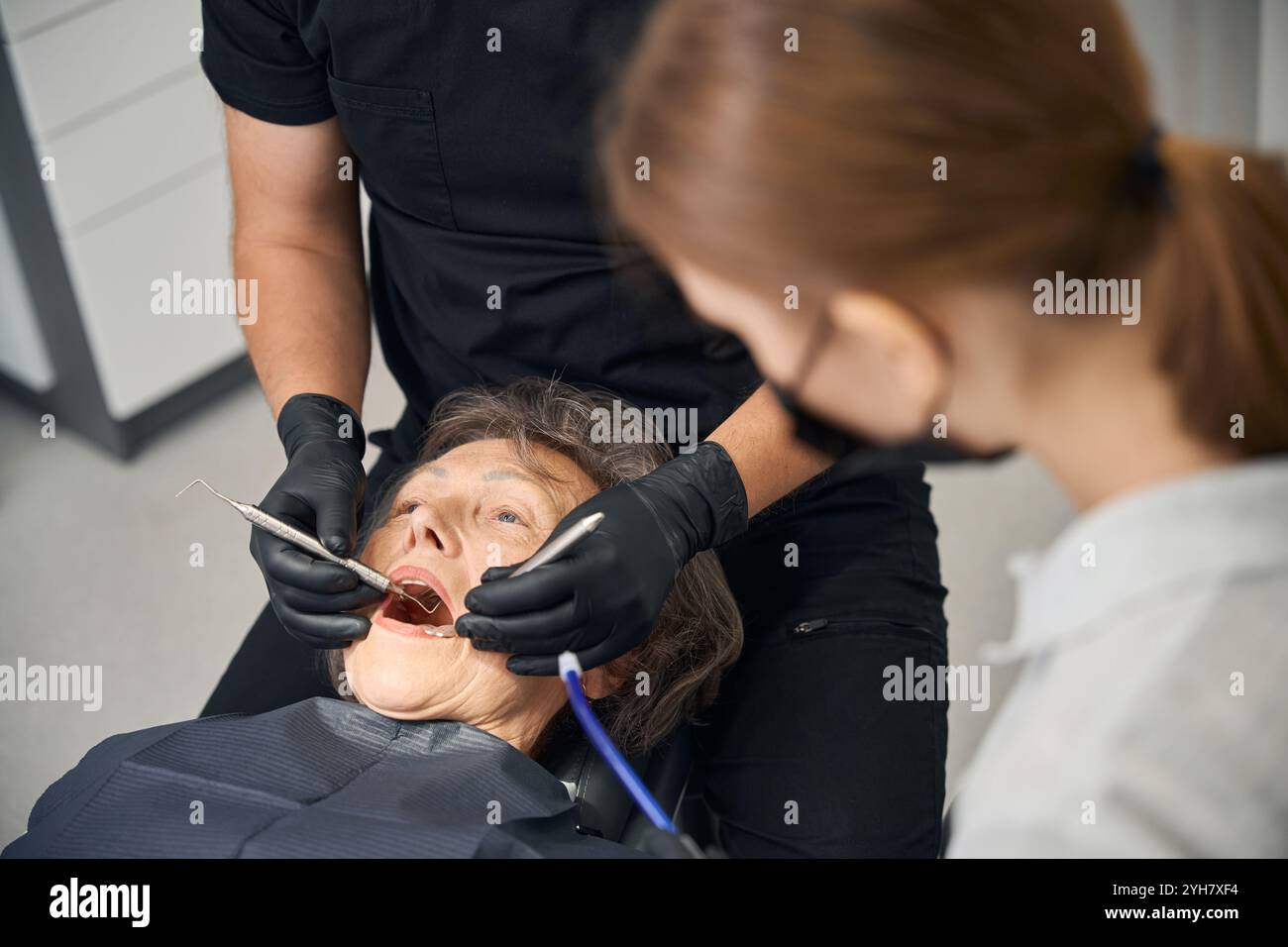 Male doctor treats teeth of elderly lady Stock Photo - Alamy