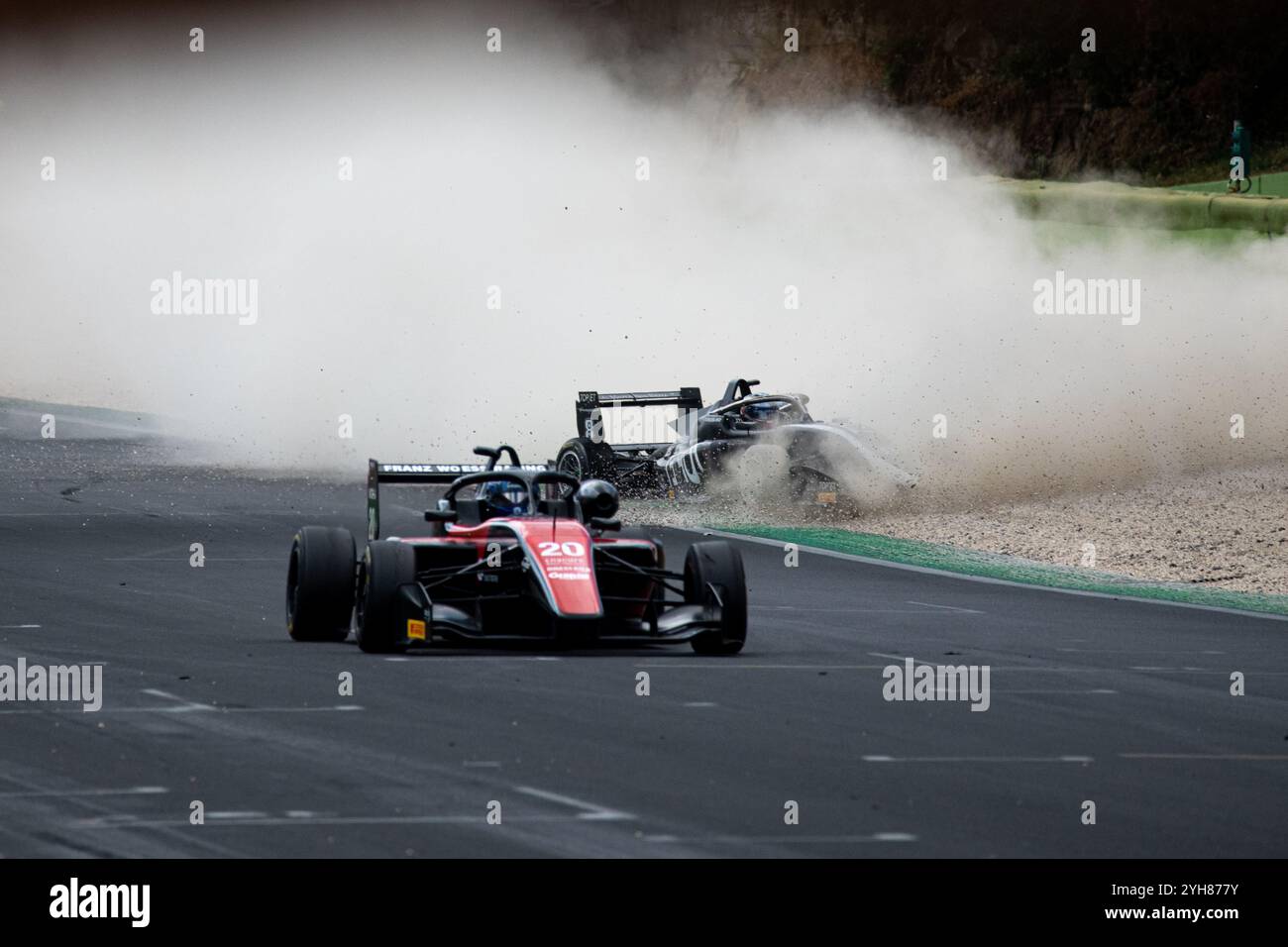 Red and black open wheel racing car overtaking another car leaving the ...
