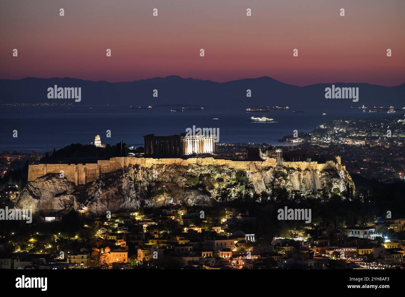 A view of Athens city and the Acropolis hill with the Parthenon Temple half illuminated during ...