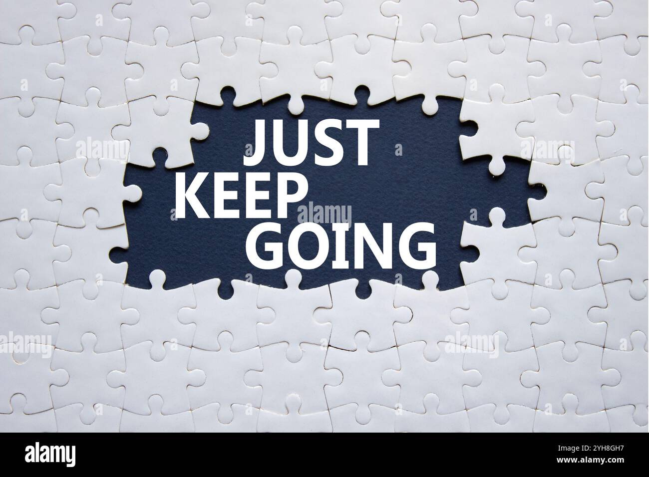 Just keep going symbol. White puzzle with words Just keep going. Beautiful deep blue background ...