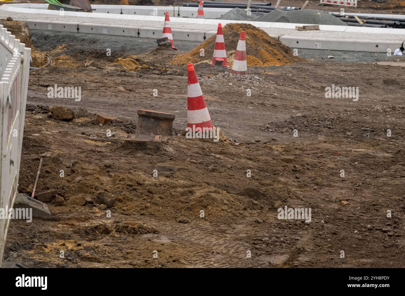 Road construction site featuring traffic cones, dirt piles, indicating ...