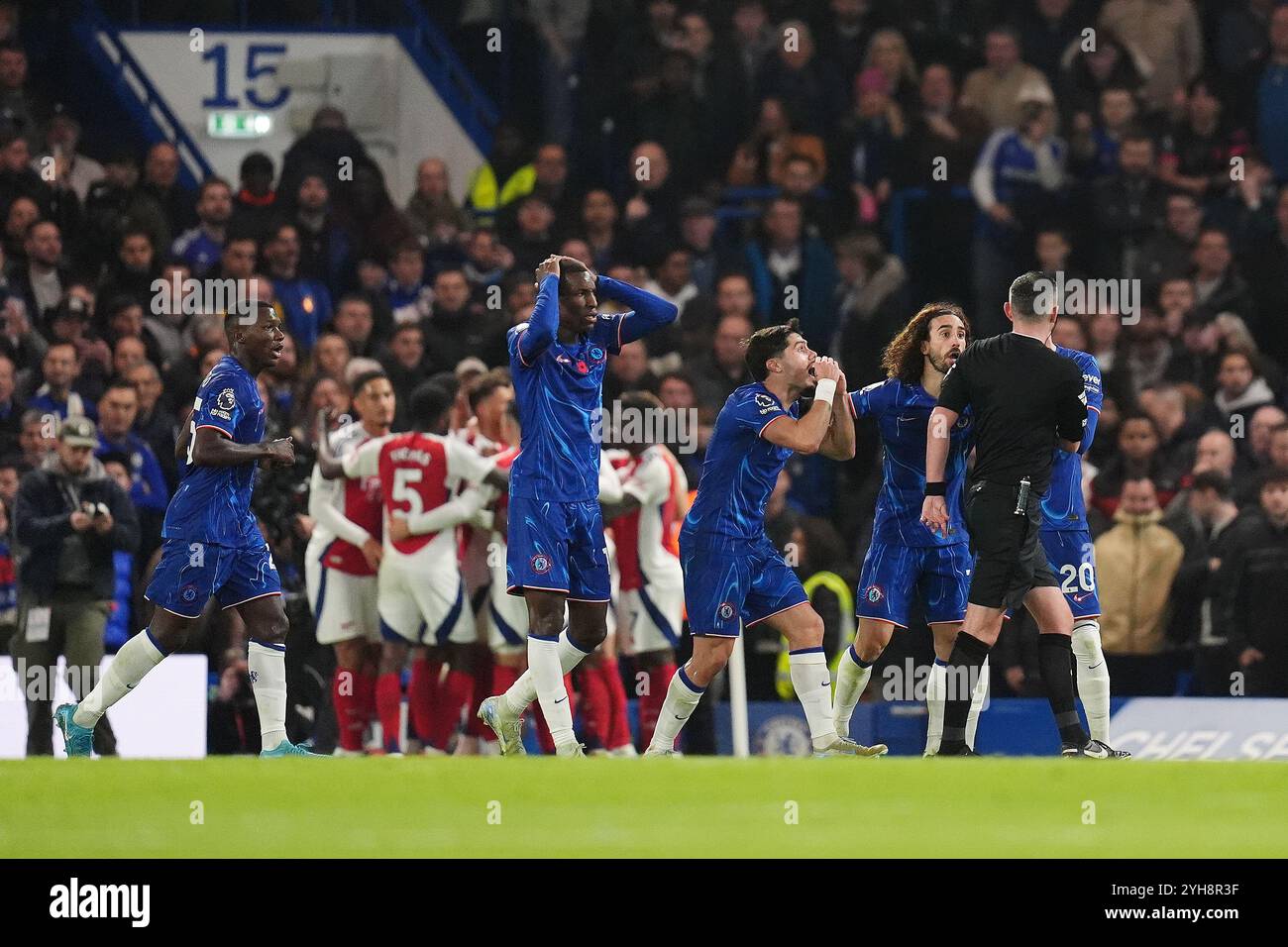 Chelsea players surround referee Michael Oliver after Arsenal's Kai ...