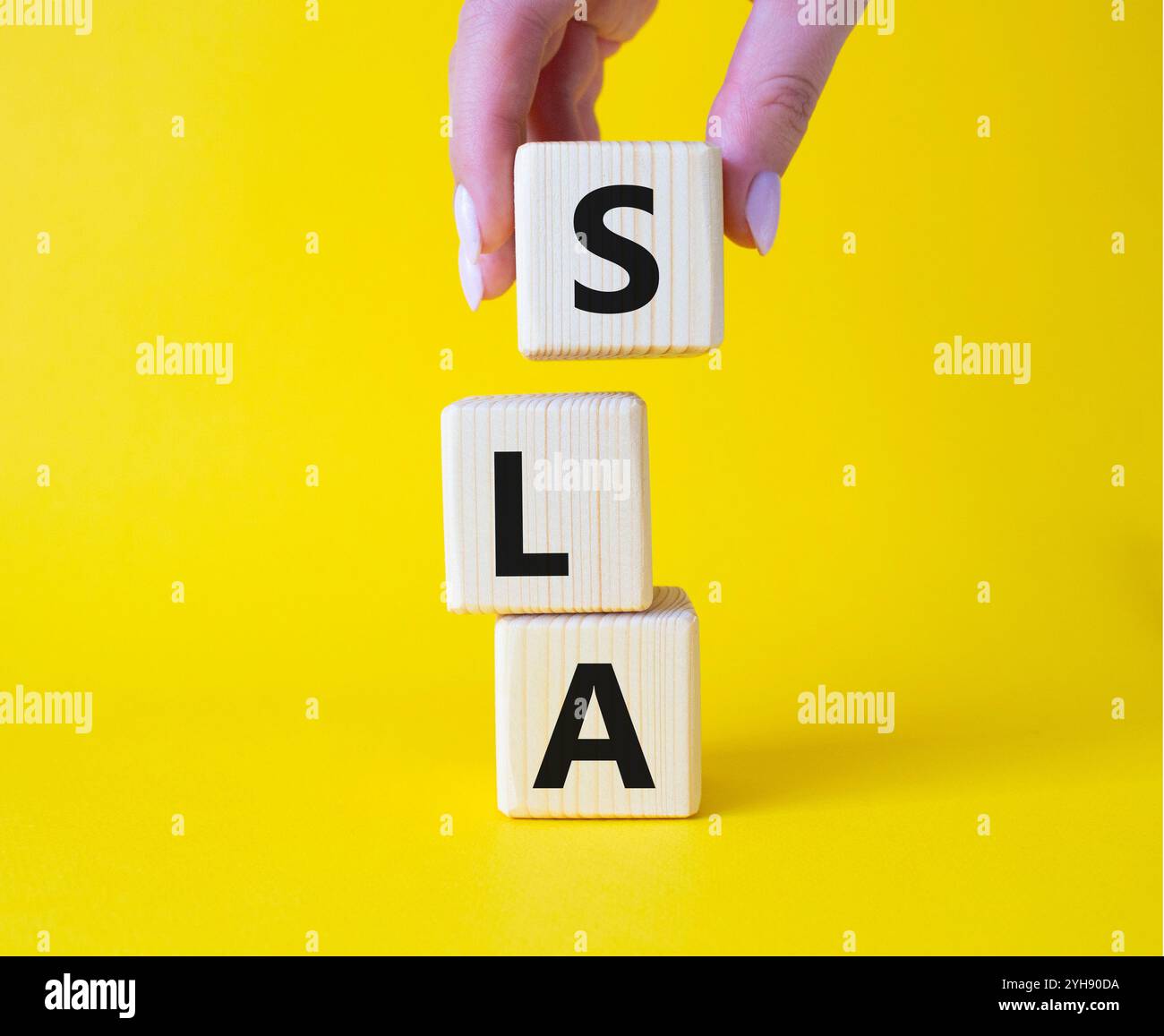 SLA - Service Level Agreement. Wooden cubes with word SLA. Businessman ...