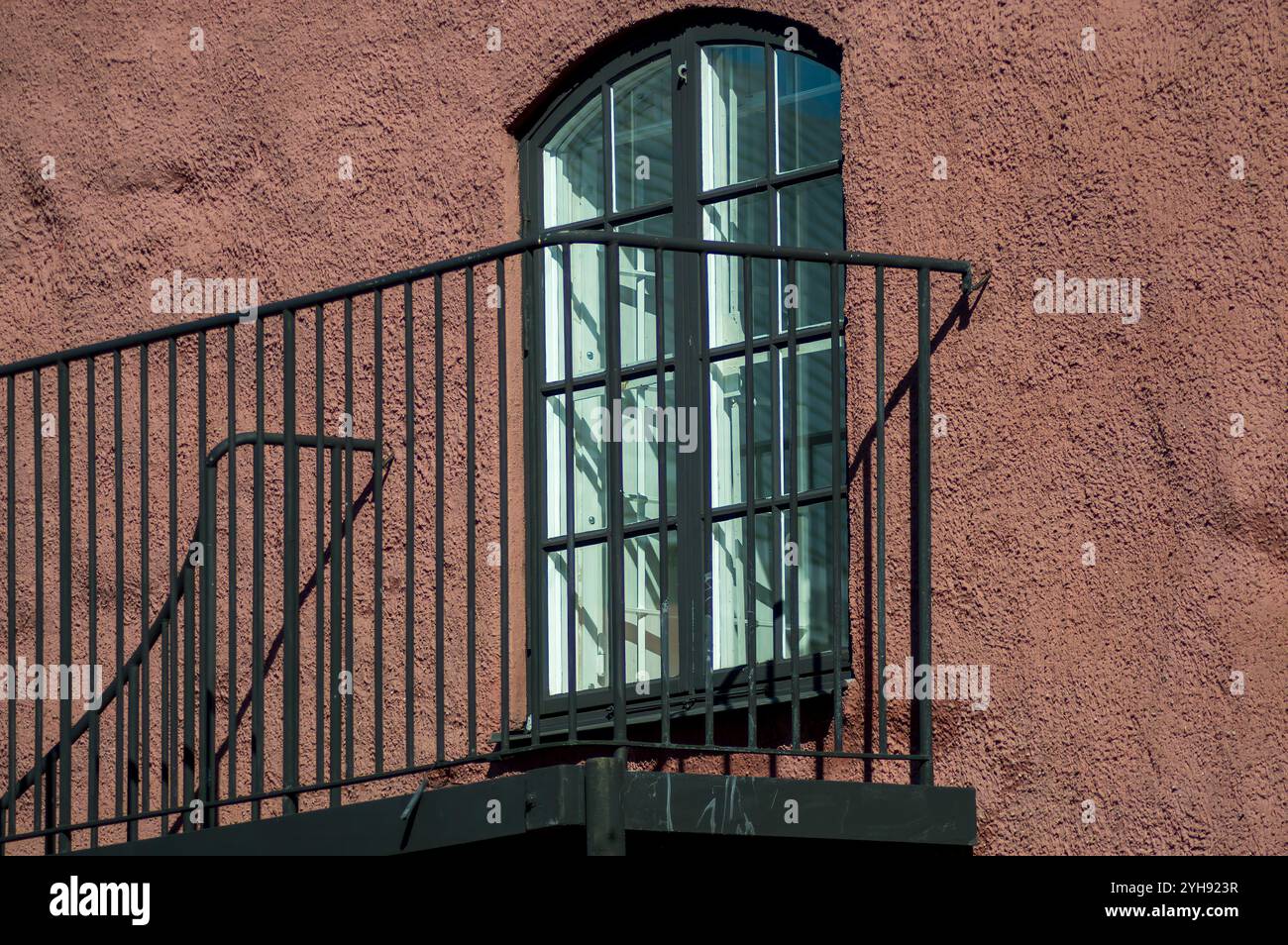 The sturdy black railing leads up to a large, elegant window set within ...