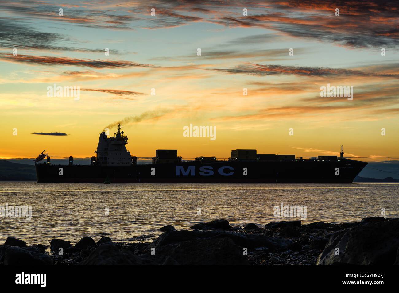 Silhouetted container ship at sunrise hi-res stock photography and ...