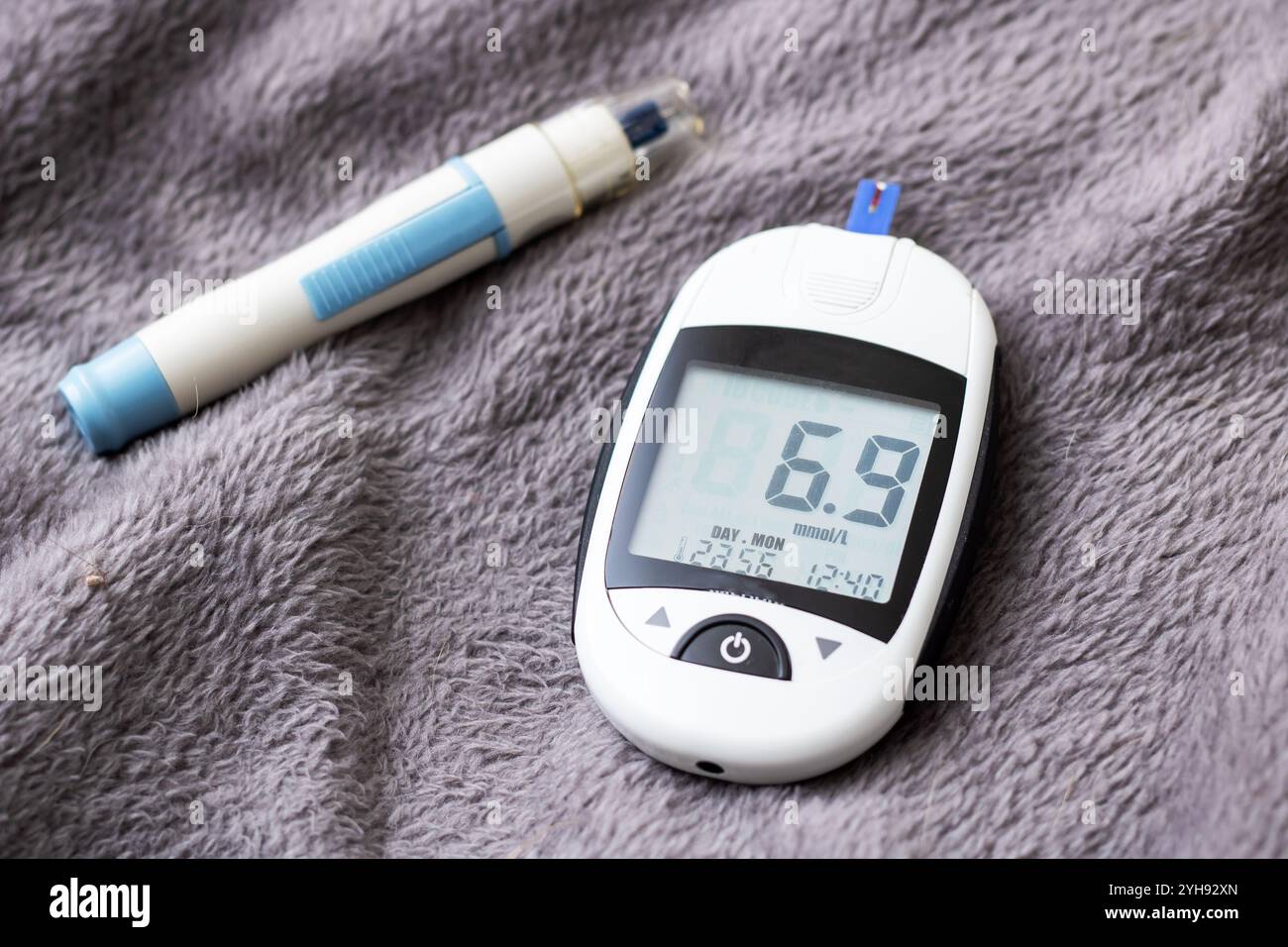 A glucose meter provides a reading alongside an insulin injection pen ...