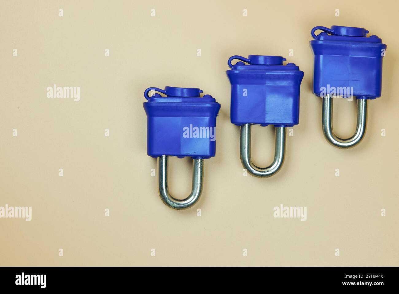 Padlock with blue plastic insulation and key, on a beige background ...