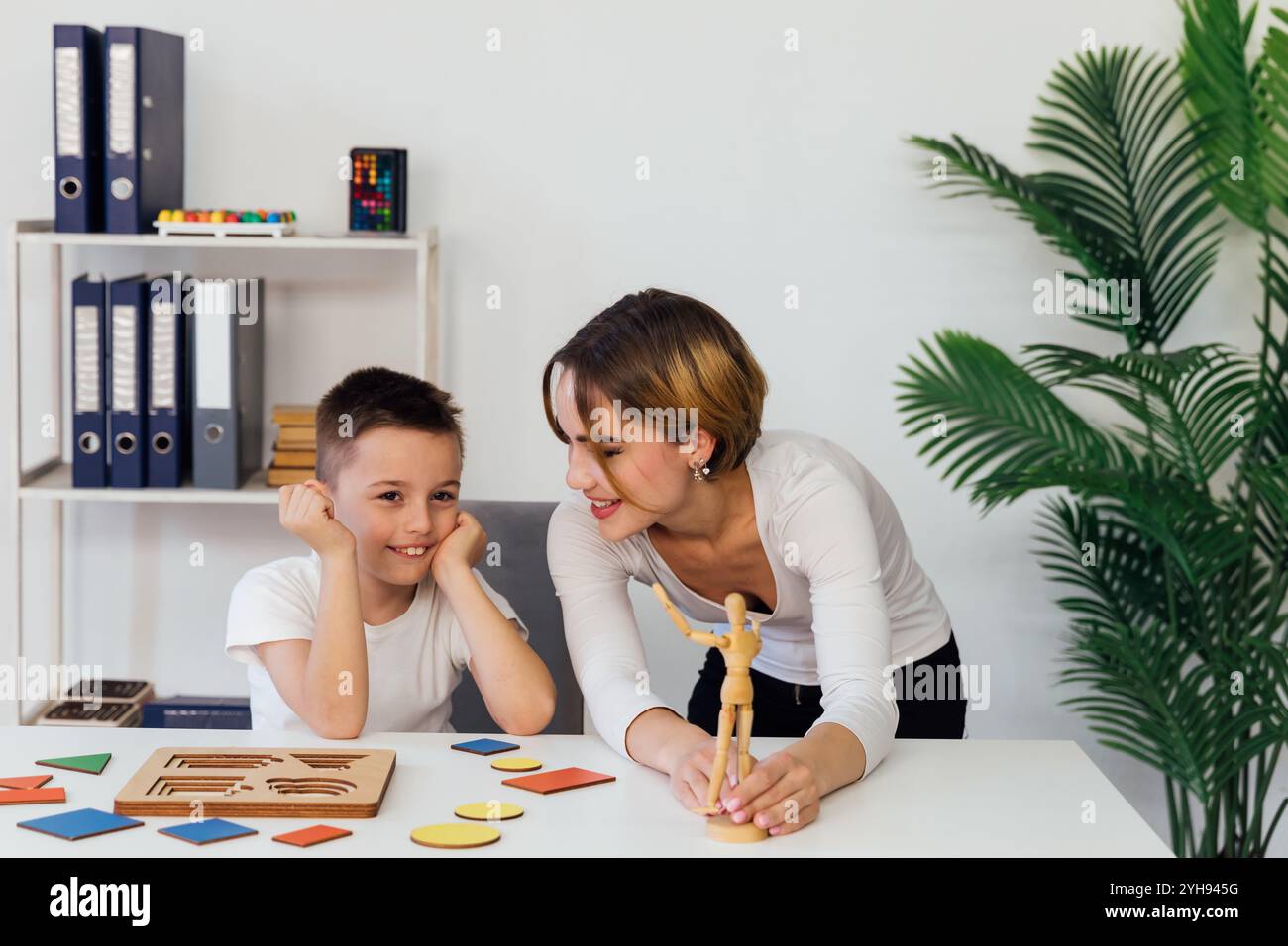 A female teacher conducts developmental training sessions with a boy ...