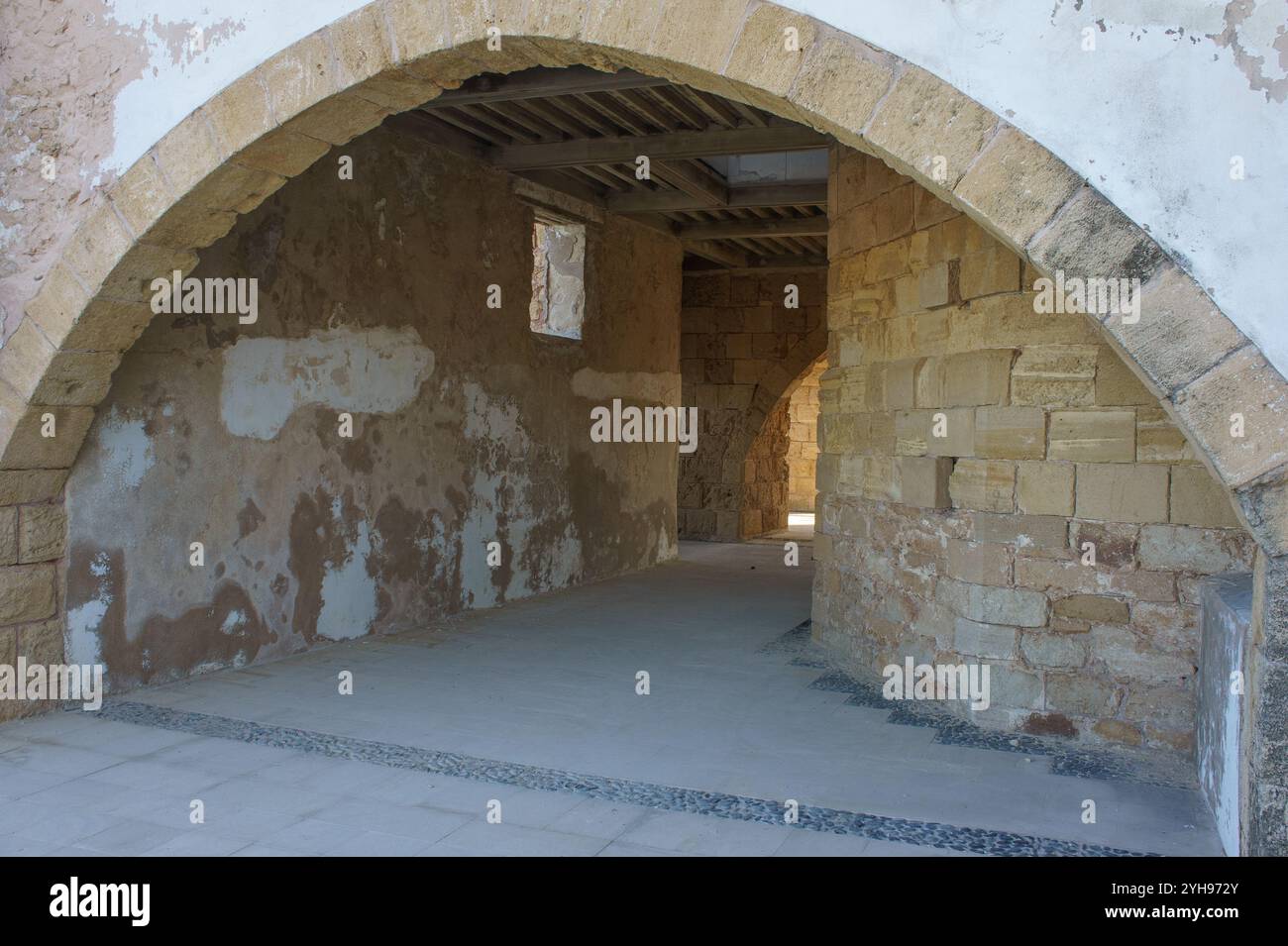 Wander through an enchanting stone corridor with arched ceilings and ...