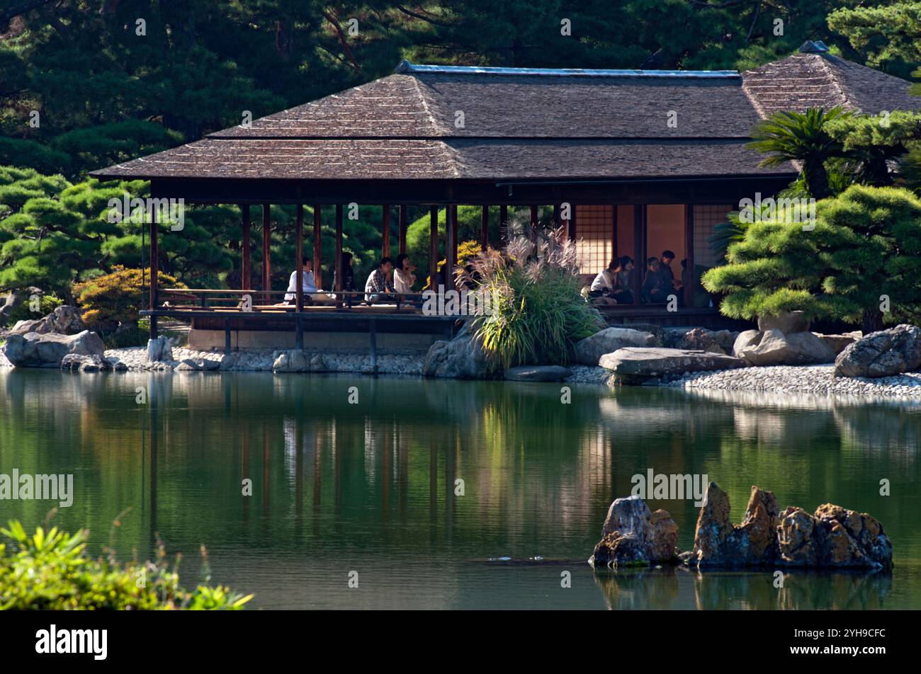 People relaxing in the Kikugetsutei tea house in the background at ...
