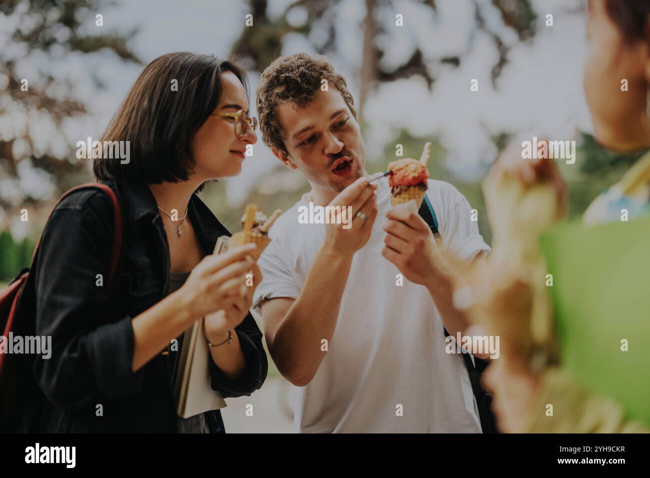Multicultural students enjoying ice cream in a park between classes Stock Photo - Alamy