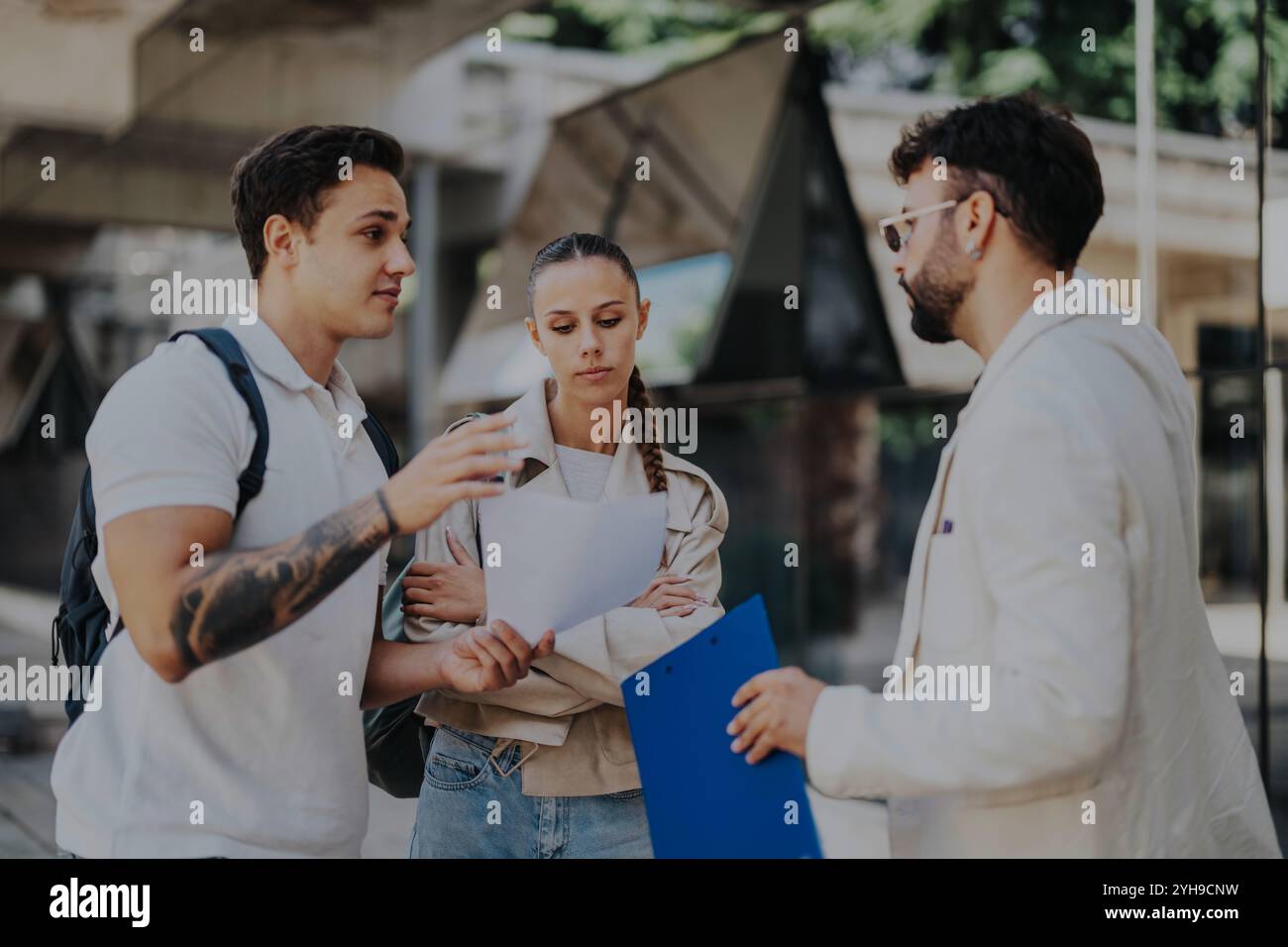 Students discussing with professor outdoors on university campus Stock ...