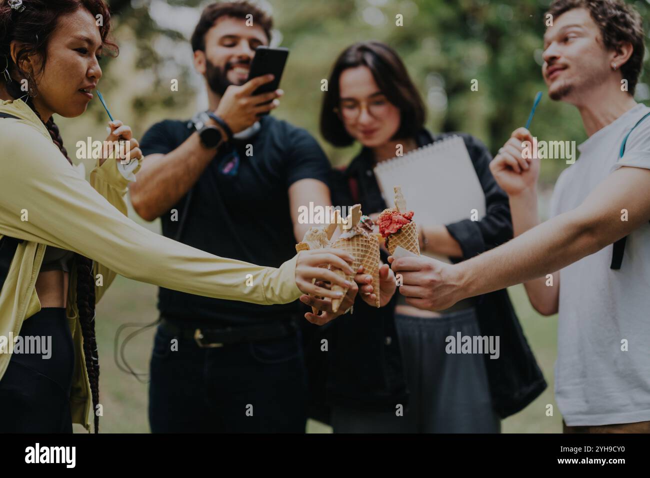 Multicultural students enjoying ice cream together in a park break Stock Photo - Alamy