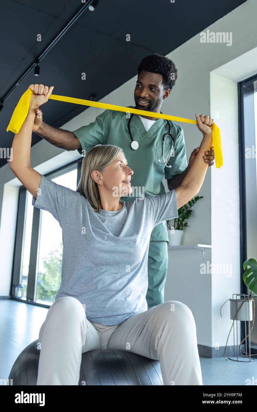 Female patient having a session of rehabilitation exercises, doctor ...