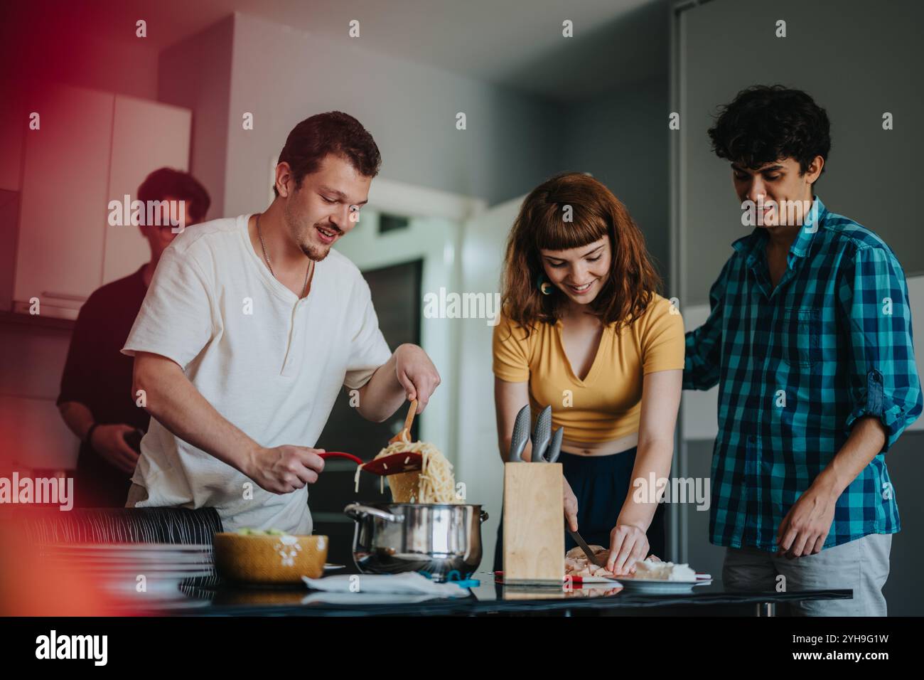 Friends enjoying cooking together in a cozy kitchen setting Stock Photo ...