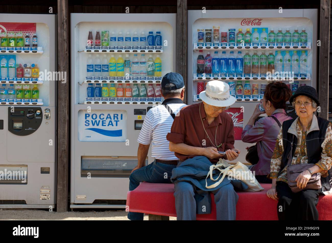 Group of senior citizens taking a break beside a row of "jidohanbaiki ...
