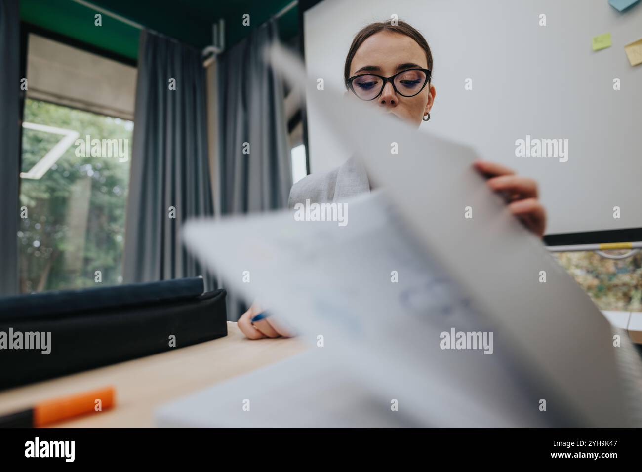 Focused student reviewing class materials in modern classroom Stock ...