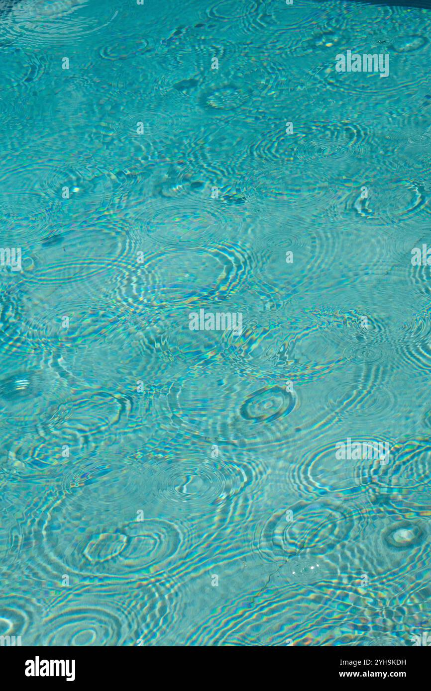 abstract image of raindrops falling on the surface of a swimming pool ...