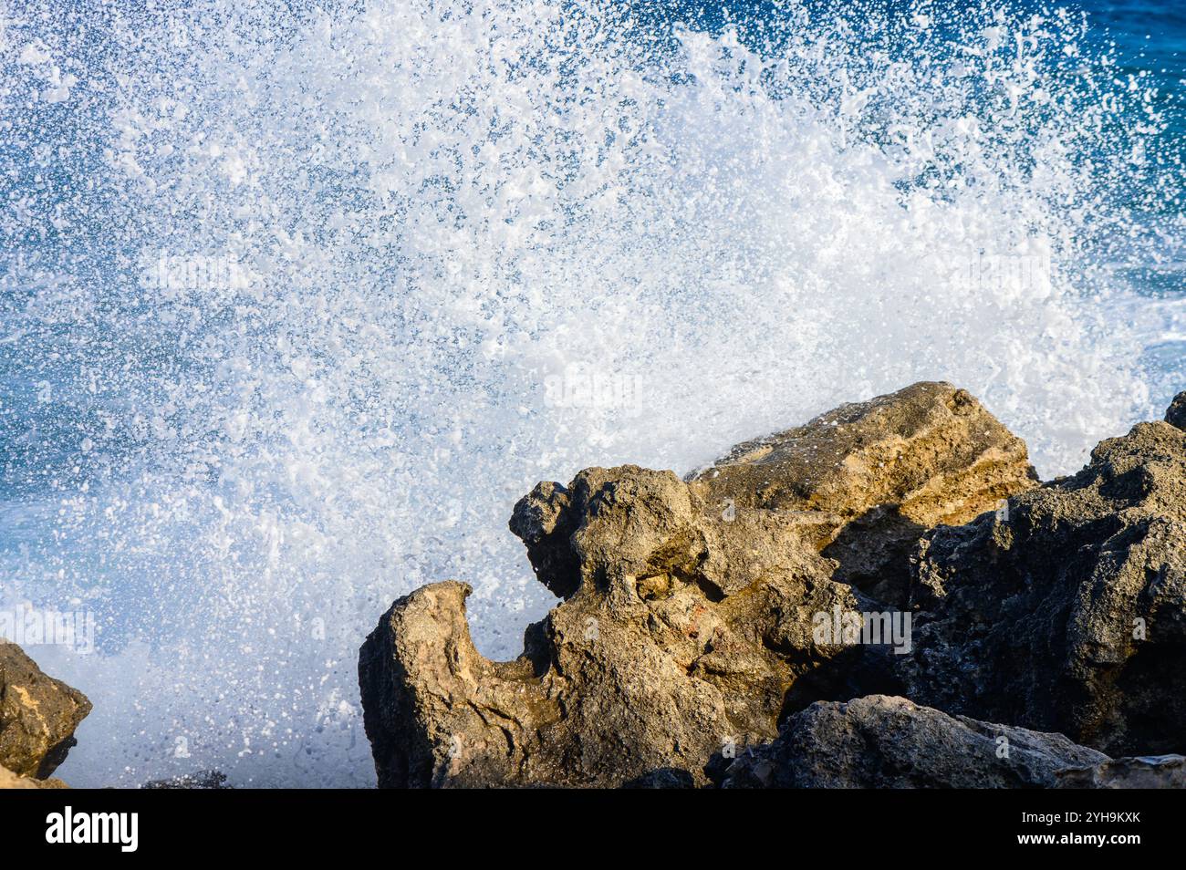 Powerful waves collide with weathered rocks, creating a striking ...