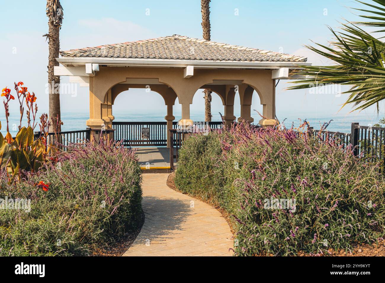 A charming gazebo adorned with vibrant flowers nestled atop a seaside ...