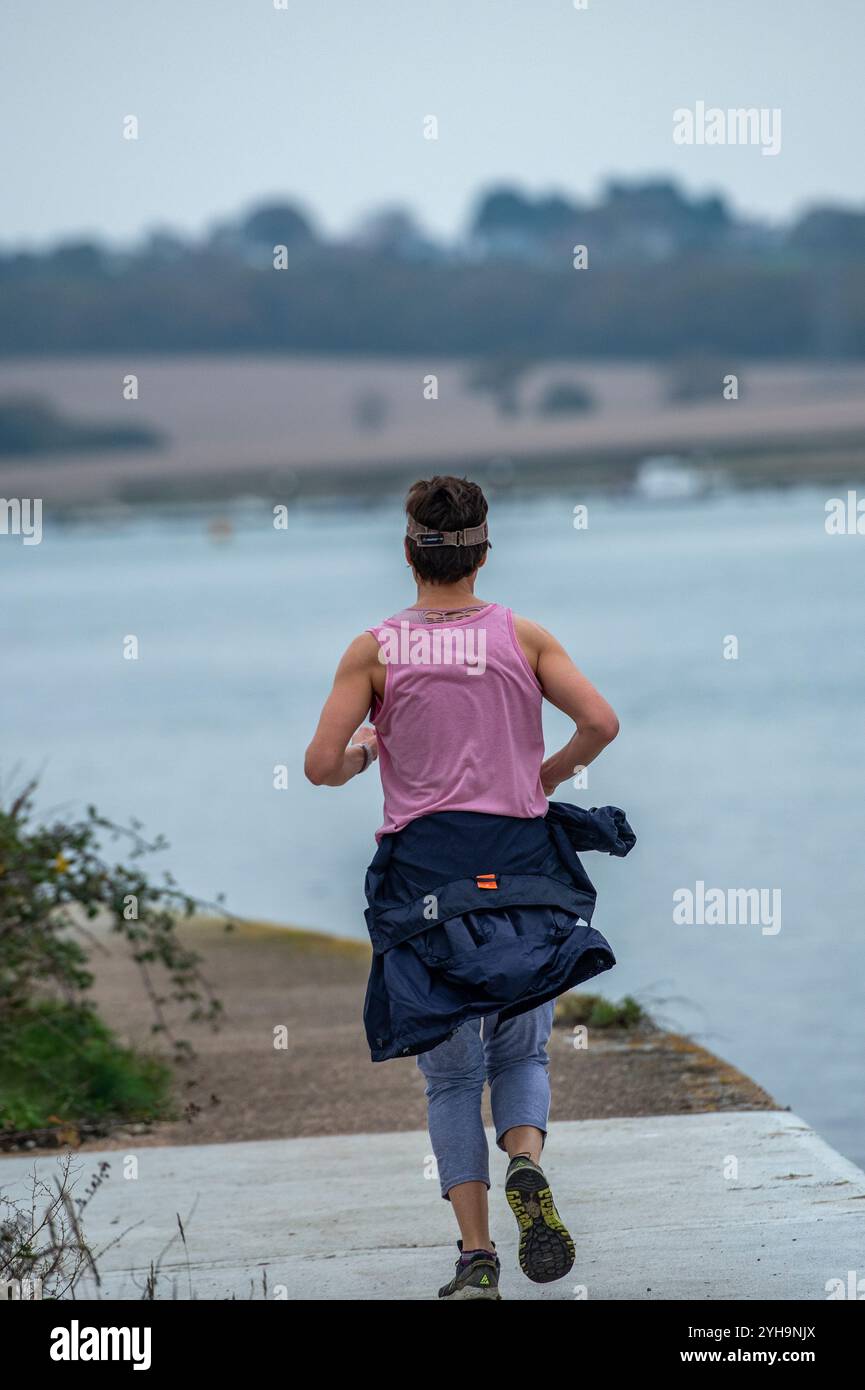 woman running along a riverside pathway or track alone Stock Photo - Alamy