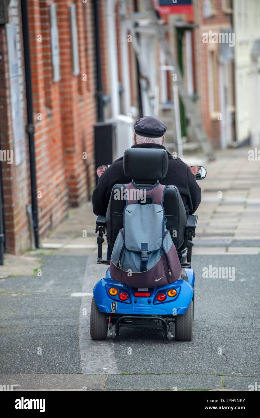 elderly gentleman driving a mobility scooter along a pavement, old man ...
