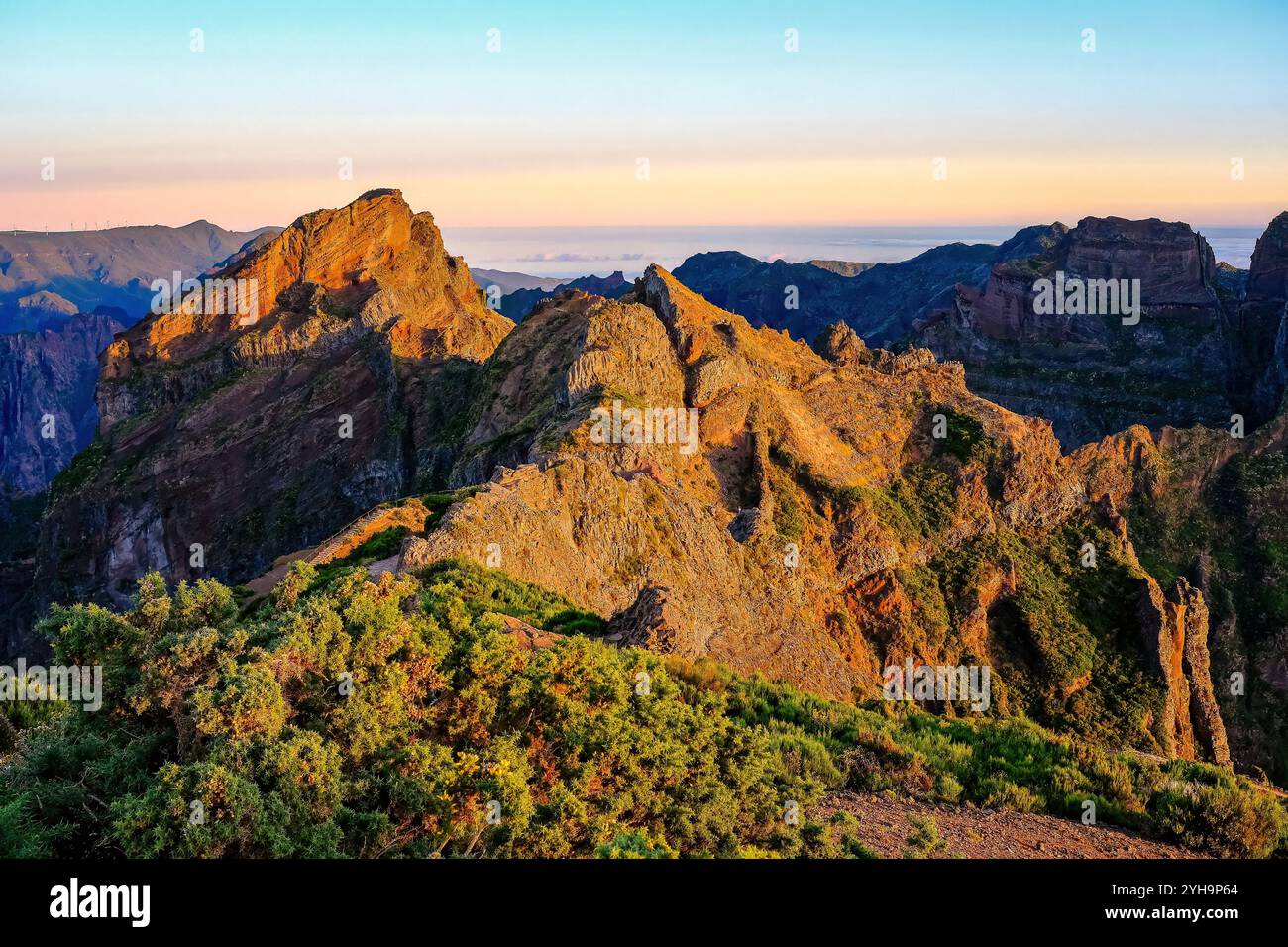 Sunrise view of rugged mountain peaks in Madeira, with warm orange and ...