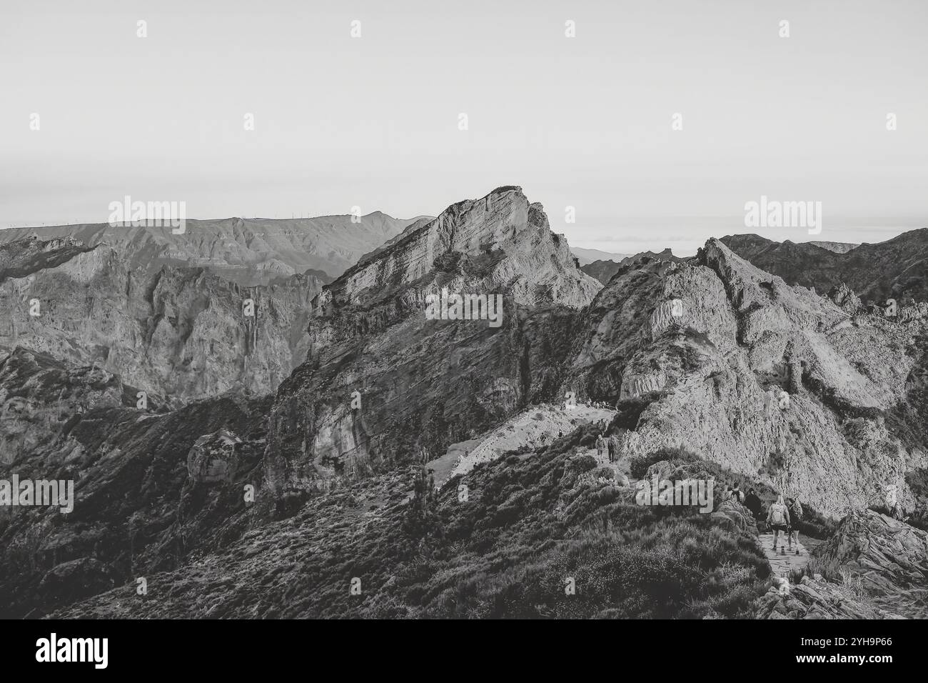 A hiker group navigating a rugged mountain trail on Madeira, surrounded ...