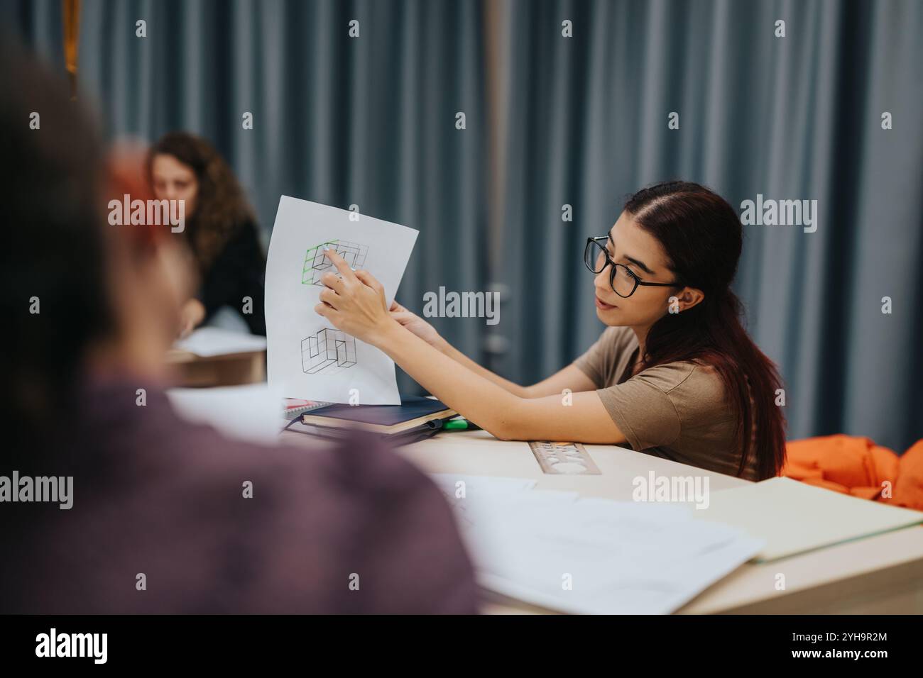 Engaged students in a classroom setting sharing ideas and discussing project designs while ...