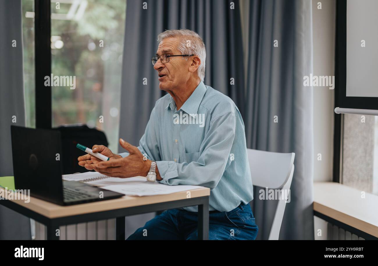 Elderly professor teaching students in a modern classroom Stock Photo ...