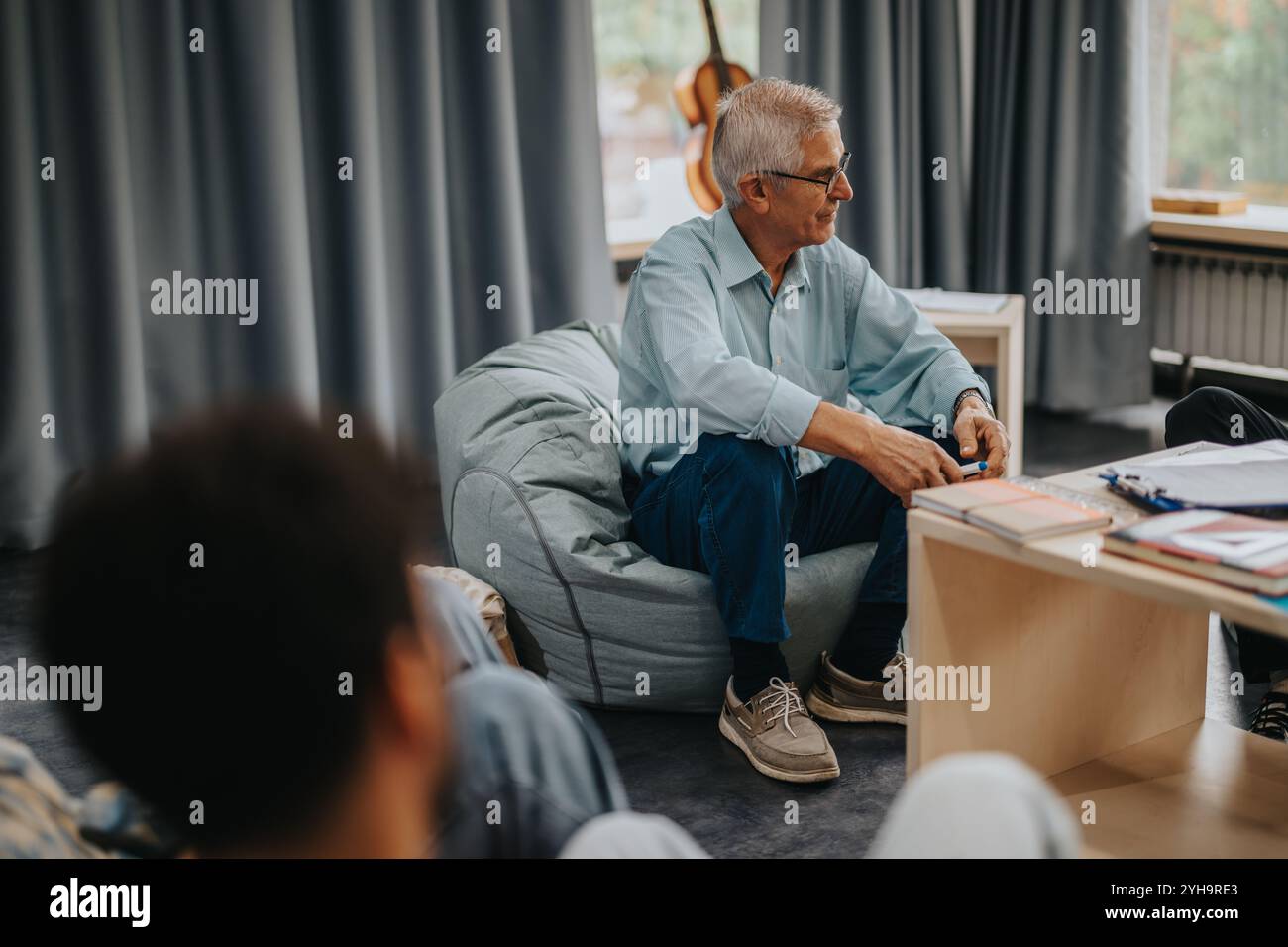 Professor engaging with students in a relaxed classroom setting Stock ...
