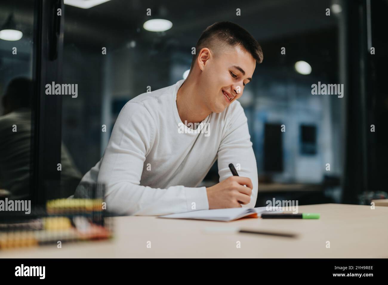 High school student smiling while studying in a modern classroom ...