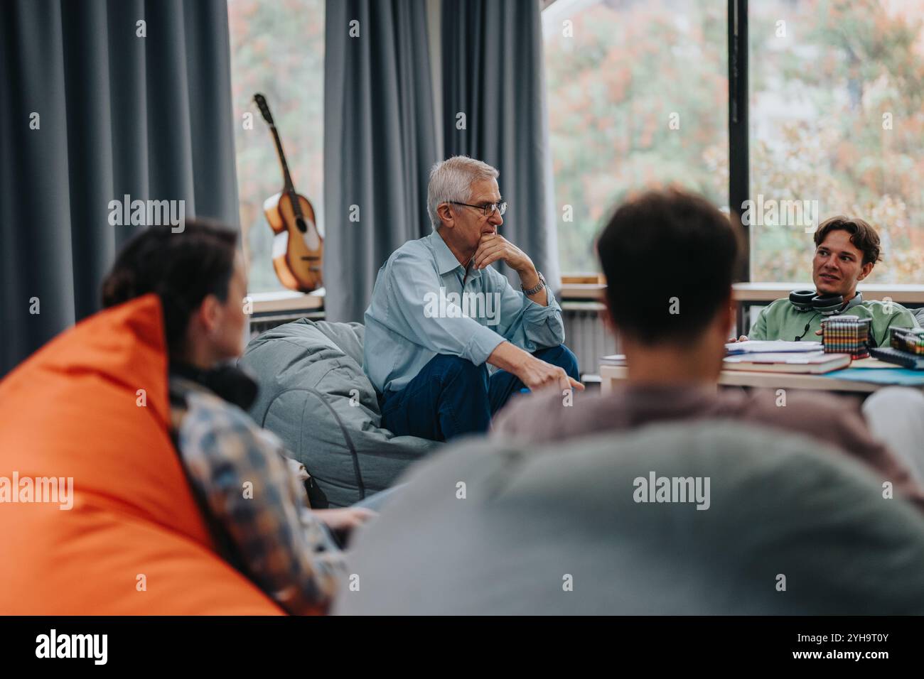 Professor engaging with students in a relaxed classroom setting Stock ...
