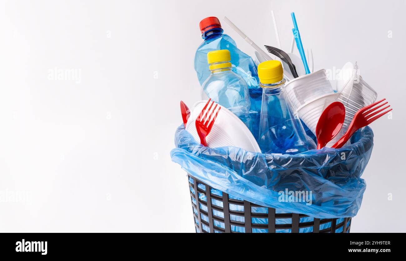 A black trash can with used plastic items isolated on white Stock Photo ...