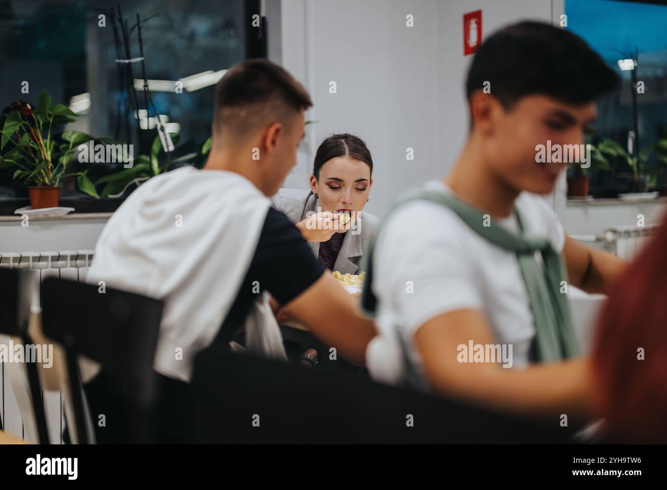 Group of students enjoying a casual meal together in a dining area ...