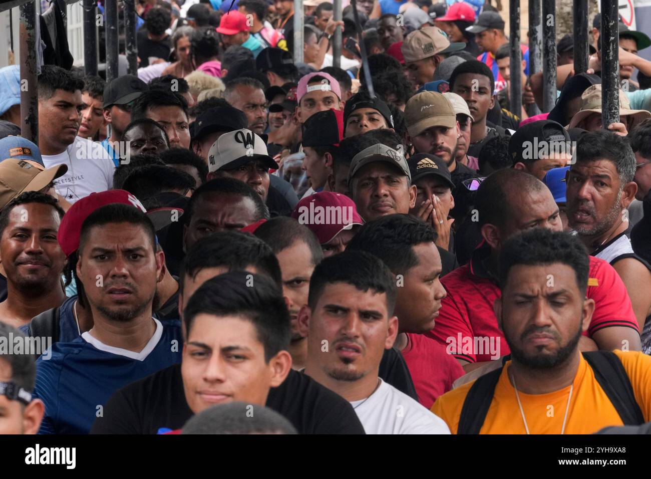 Migrants wait outside an immigration post after trekking across the ...