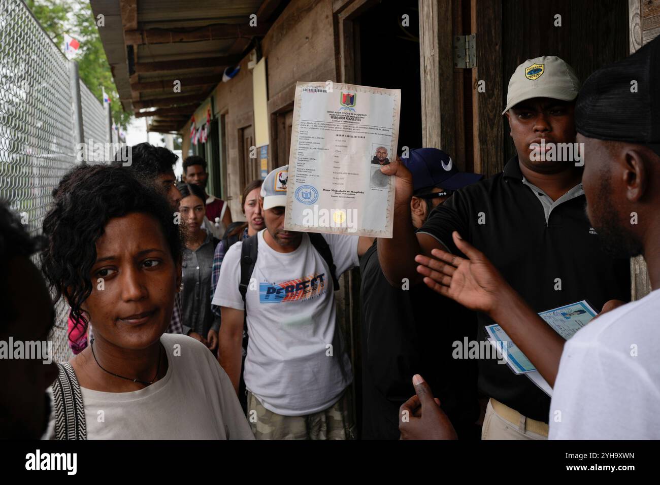 An officer shows a migrant's identification at an immigration post in ...