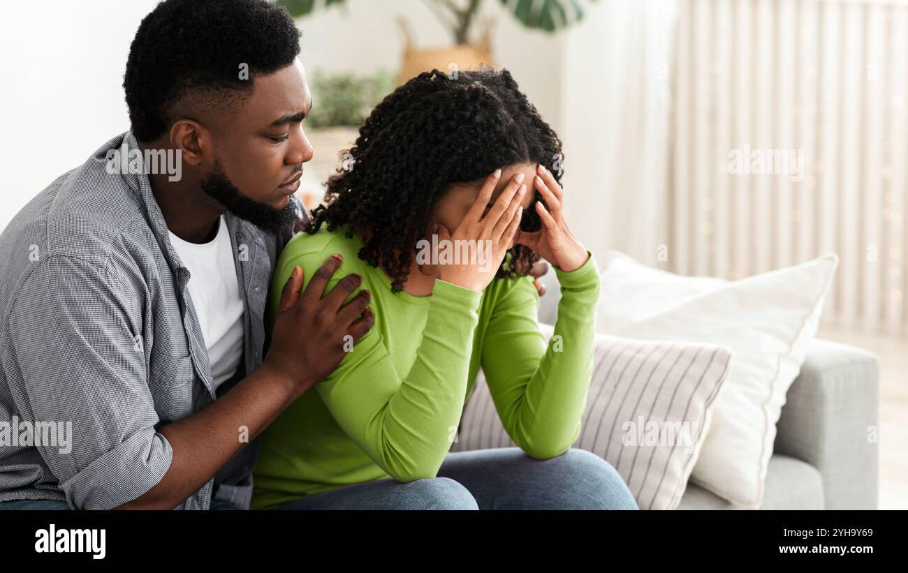 Caring black boyfriend comforting his upset crying girlfriend at home ...
