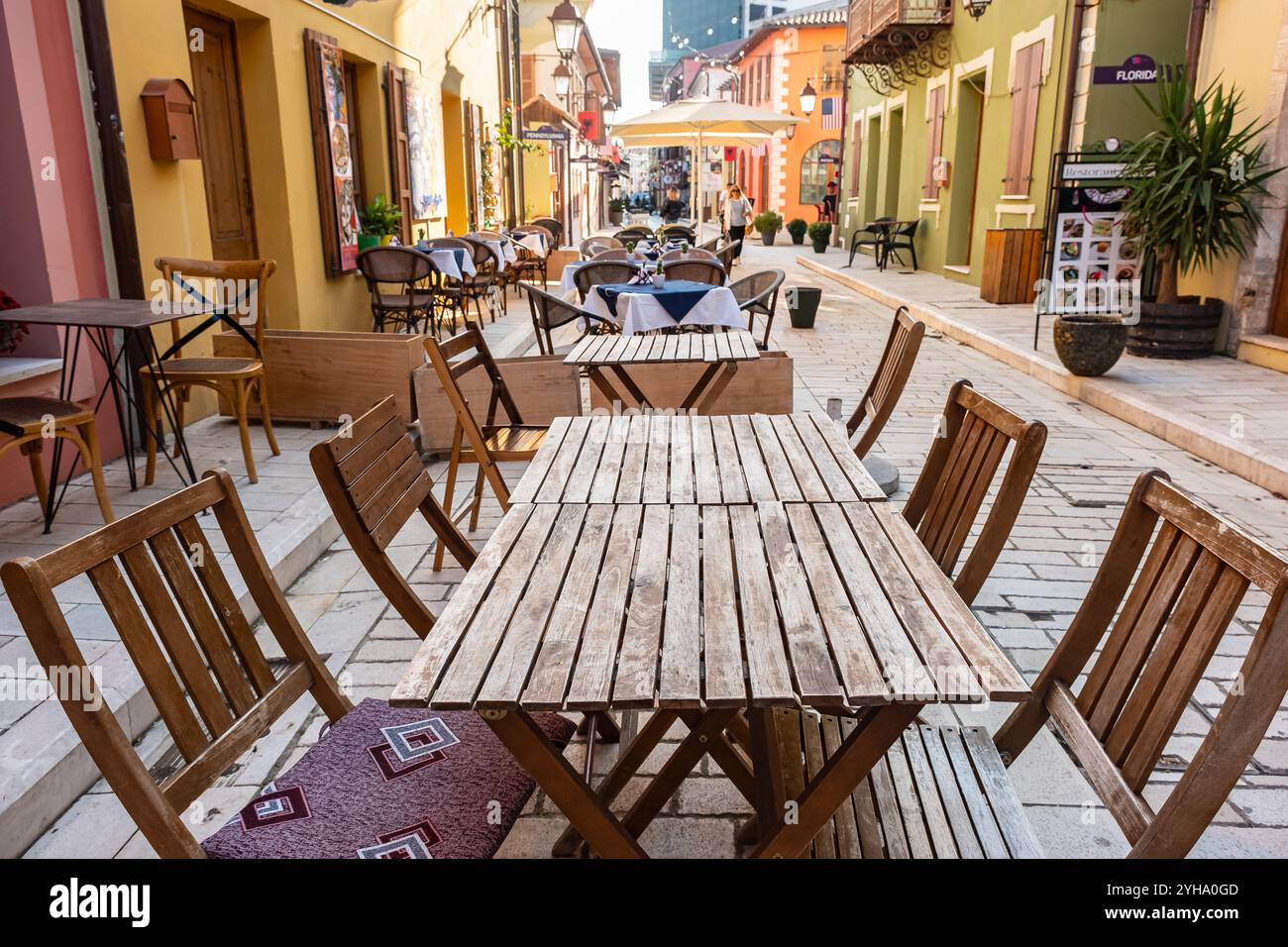 Outdoor cafe with wooden tables, stools on a city street. Historic ...