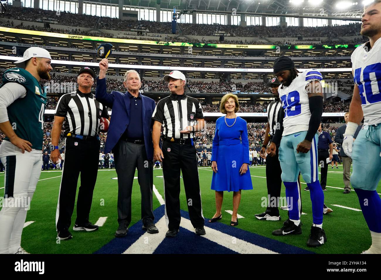 Former President George W. Bush, with cap raised, and Laura Bush ...