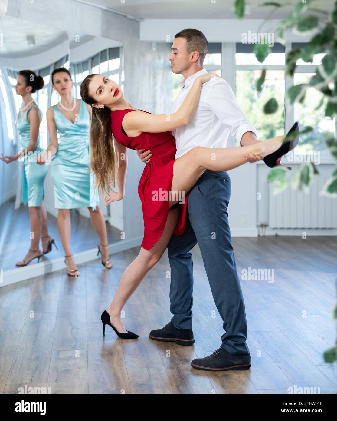 Couple in stage costumes learns tango dancing during individual lesson ...