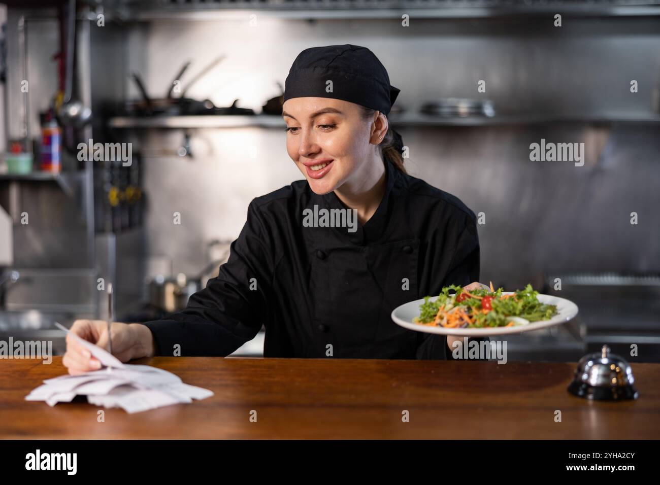 Chef checking orders and giving out salad Stock Photo - Alamy