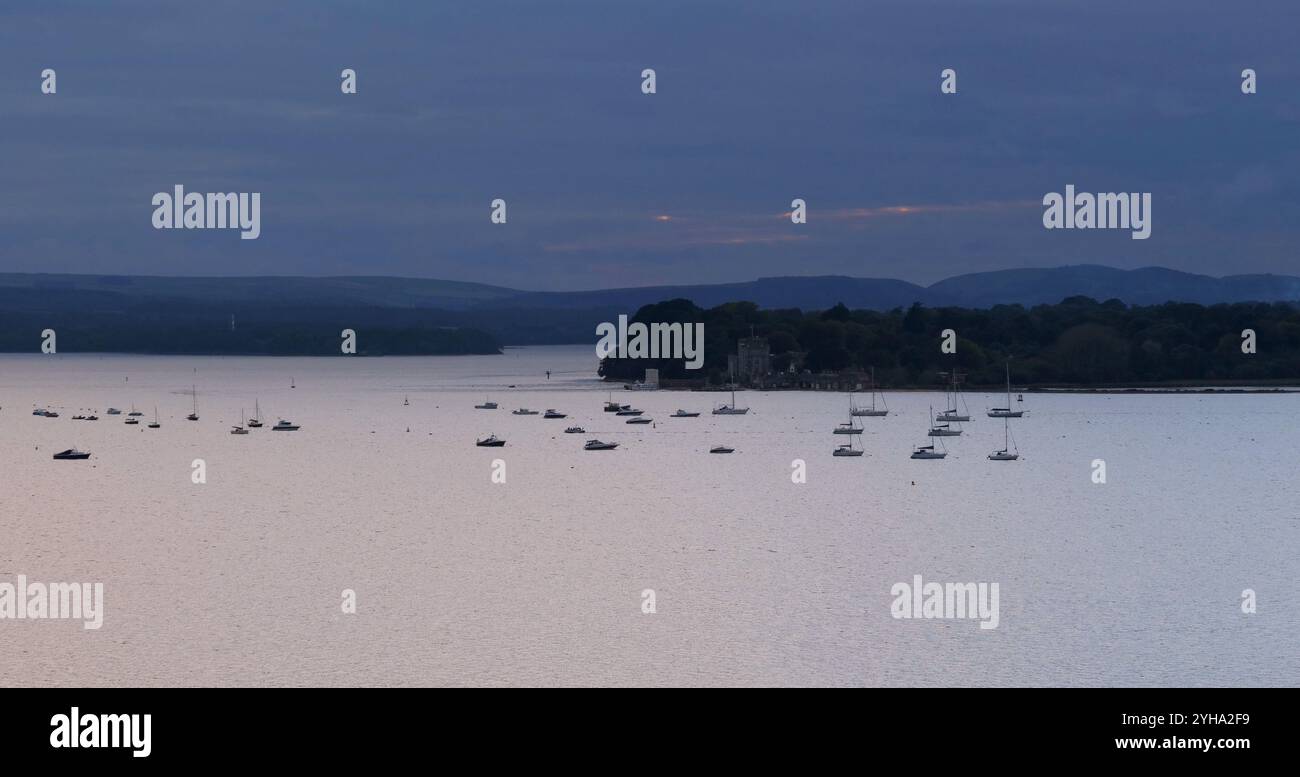 An moody evening photograph of Poole harbour featuring Brownsea island ...